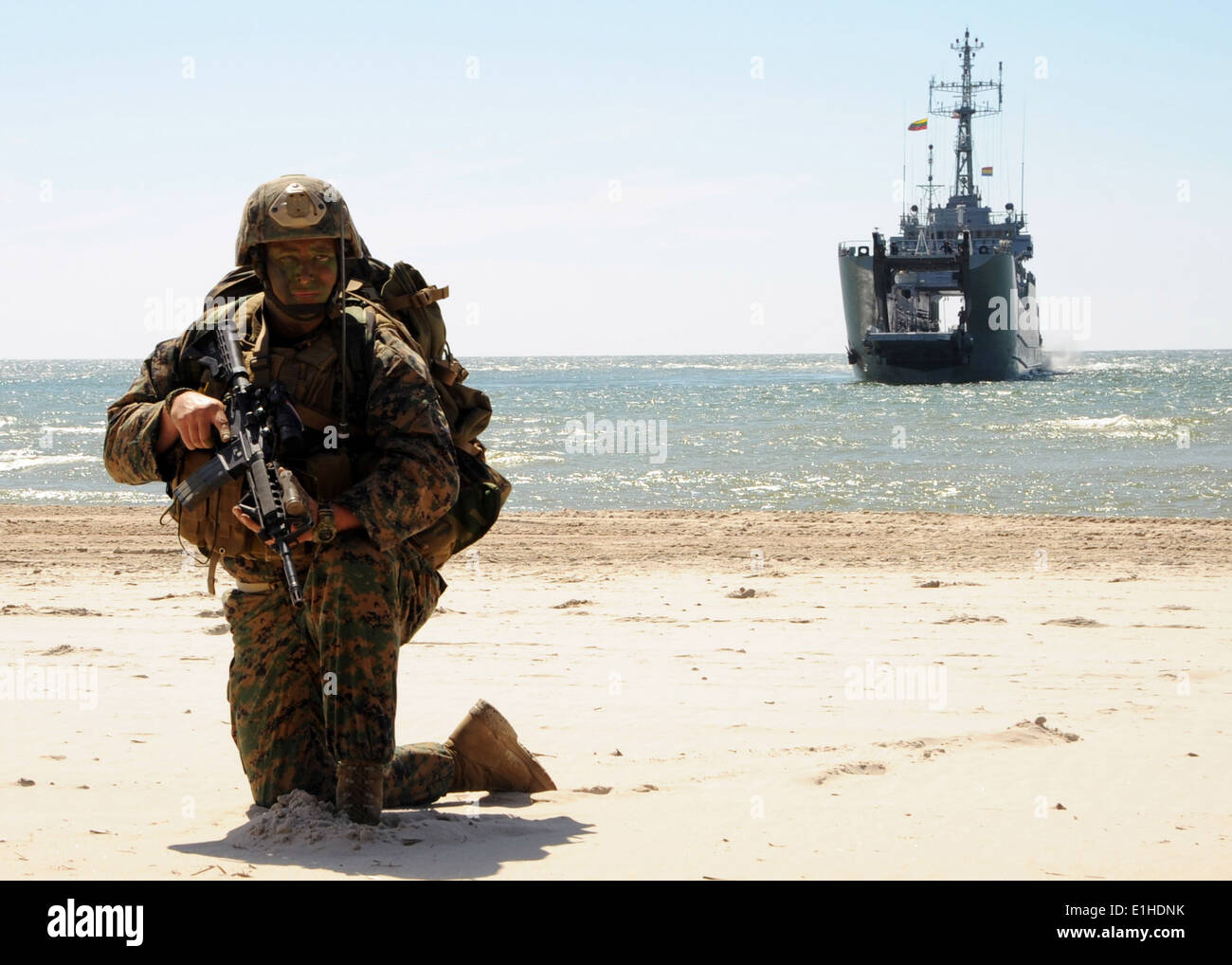 U.S. Marine Corps Sgt. Christopher Judy holds position on a beach with ...
