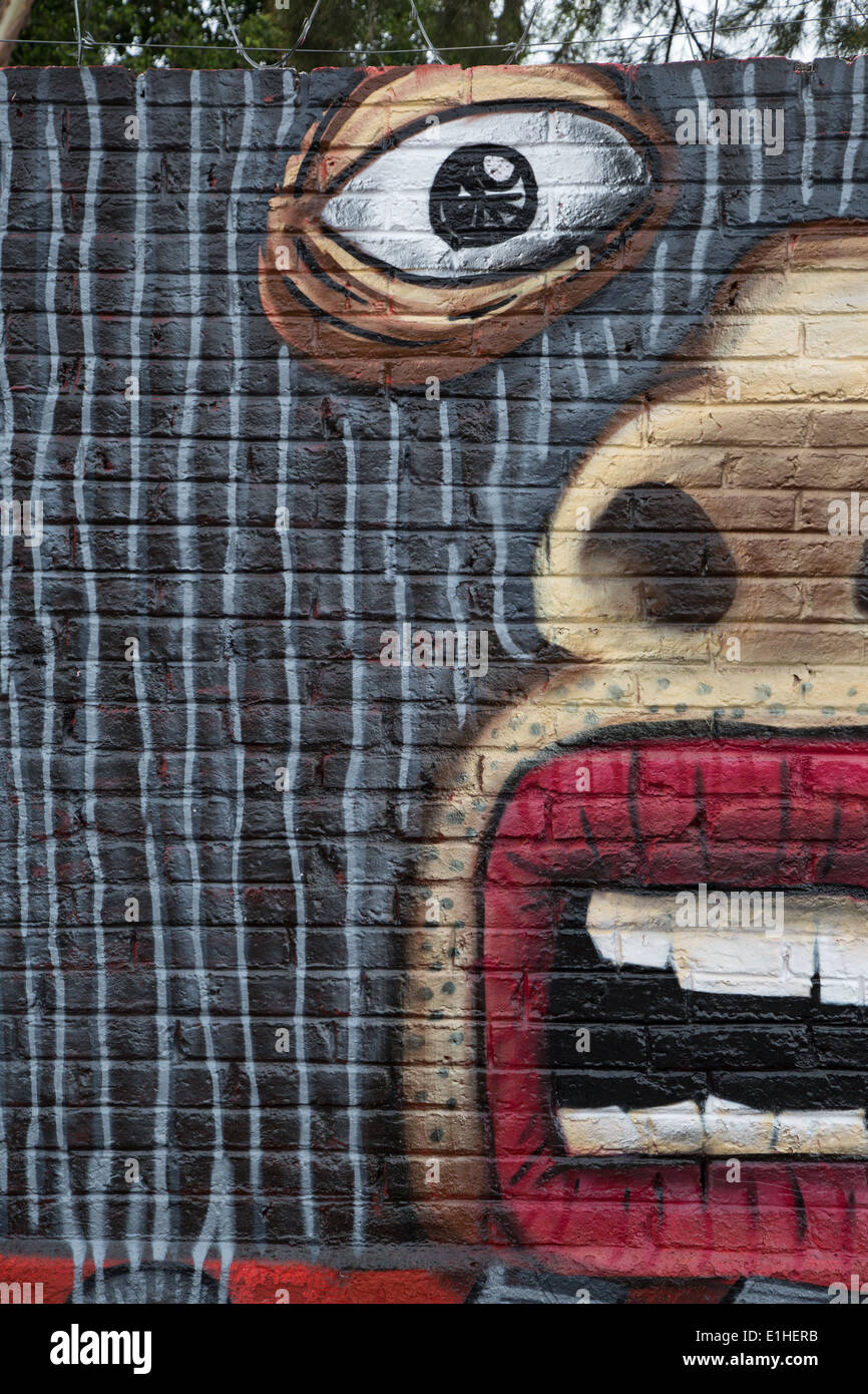 Urban art depicting a large mouth sad character in the Spanish colonial ...