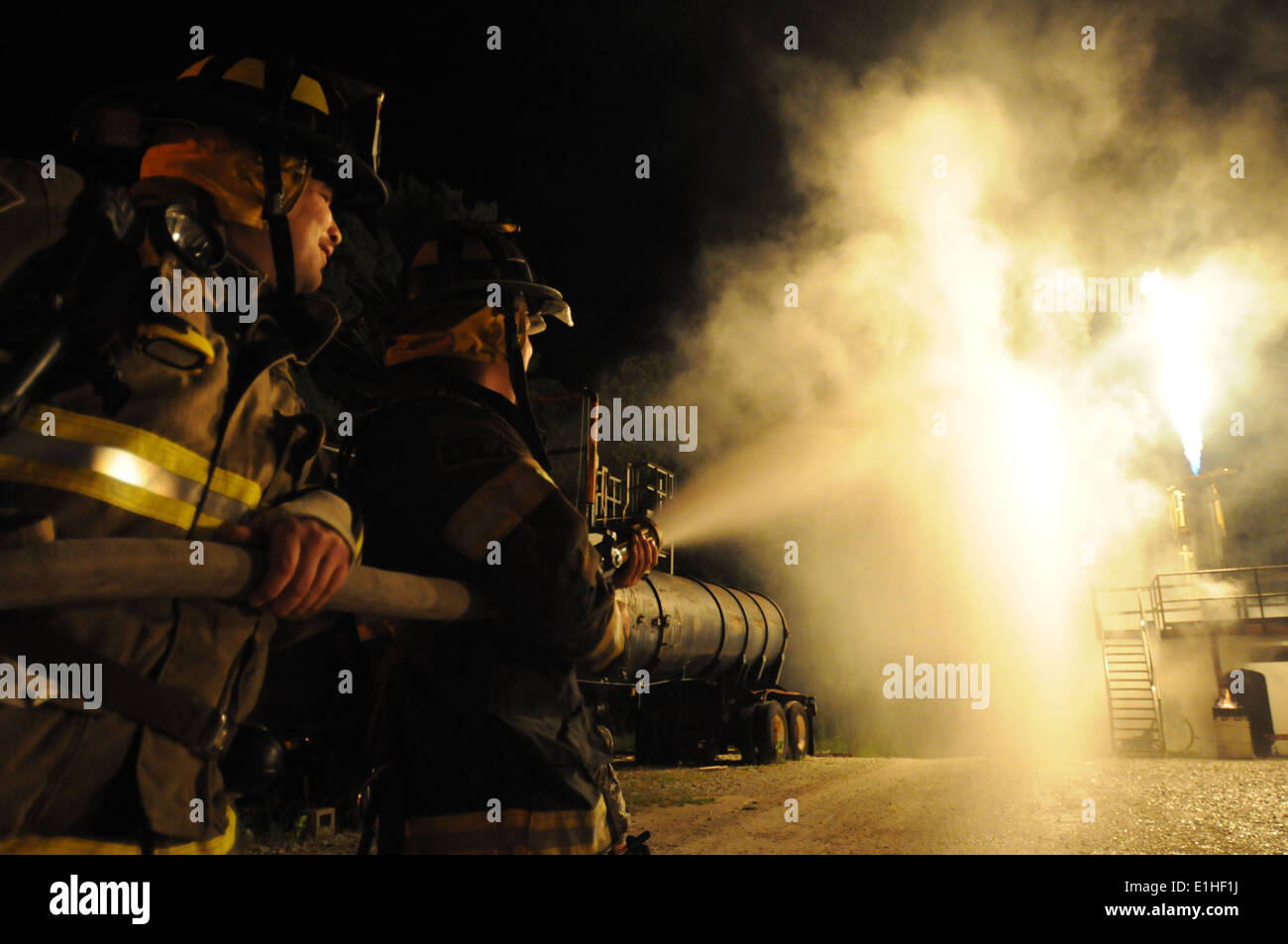 Firefighters use a high-pressure hose to extinguish a fire at the ...