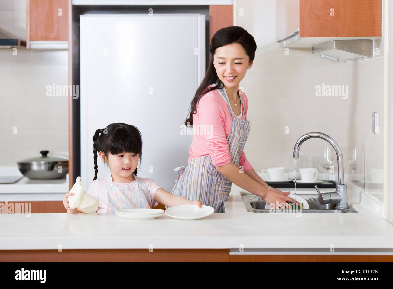 Mother and daughter washing dishes Stock Photo - Alamy