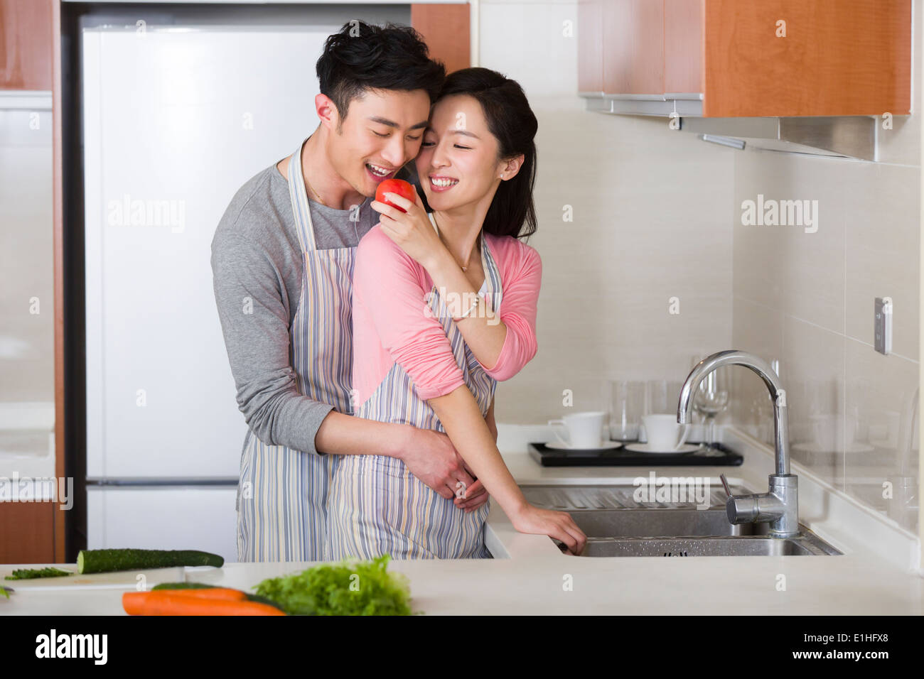 Happy young couple preparing meal Stock Photo - Alamy