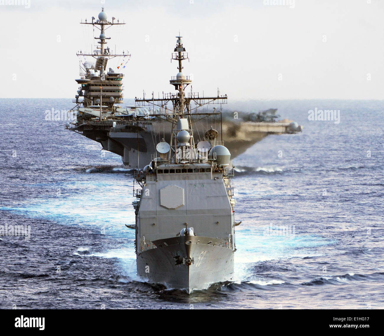 The guided missile cruiser USS Mobile Bay (CG 53), front, and the ...