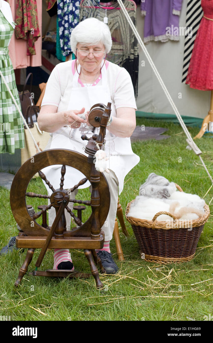 Lady using a vintage spinning wheel Stock Photo - Alamy
