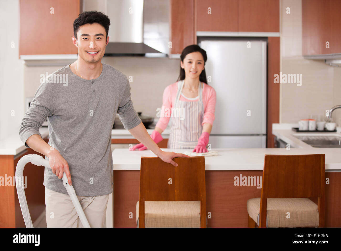 Young couple doing chores in kitchen Stock Photo - Alamy