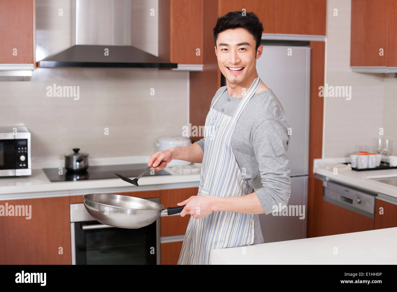 Young man cooking in kitchen Stock Photo - Alamy