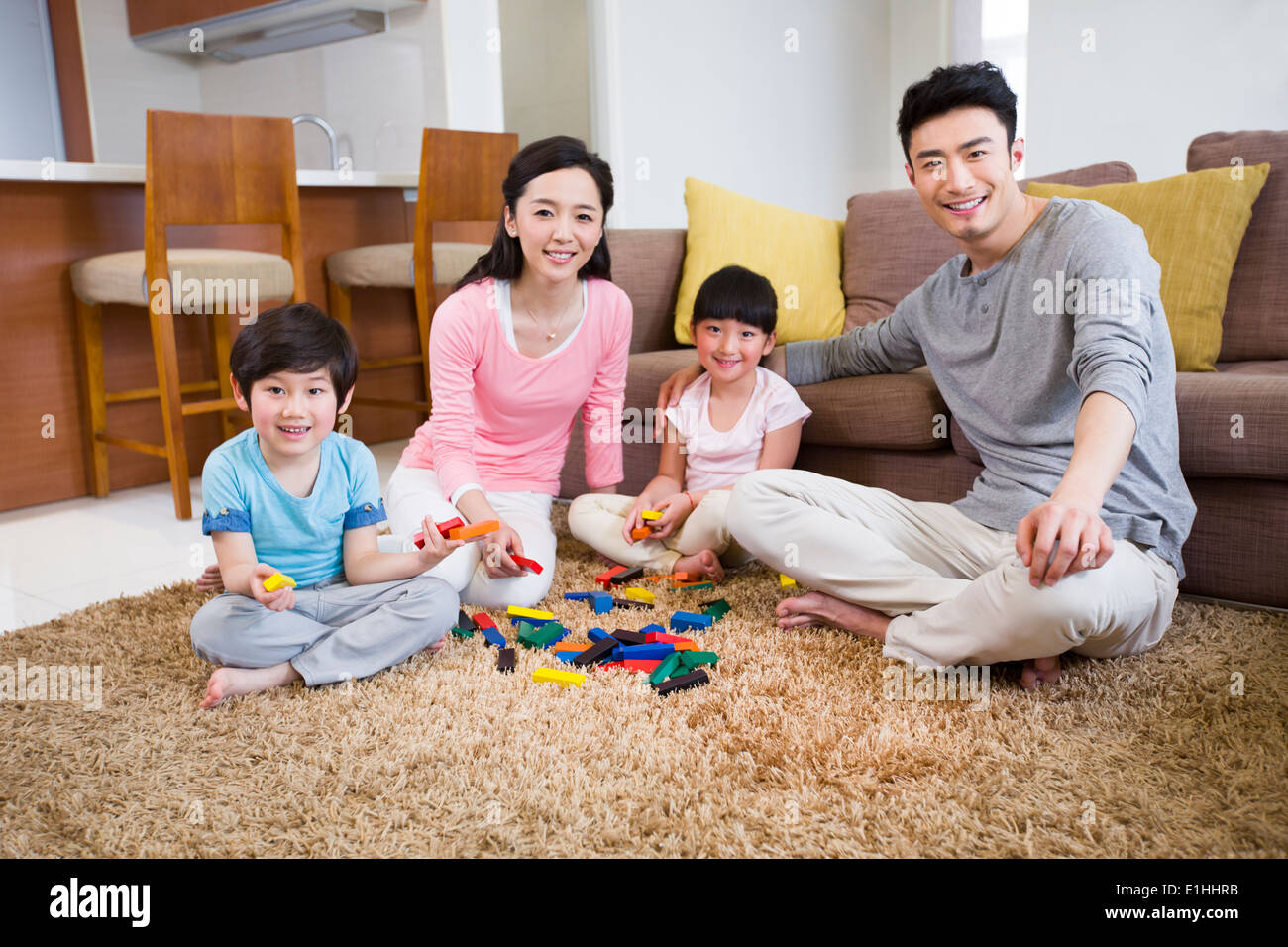 Happy family playing building blocks Stock Photo - Alamy