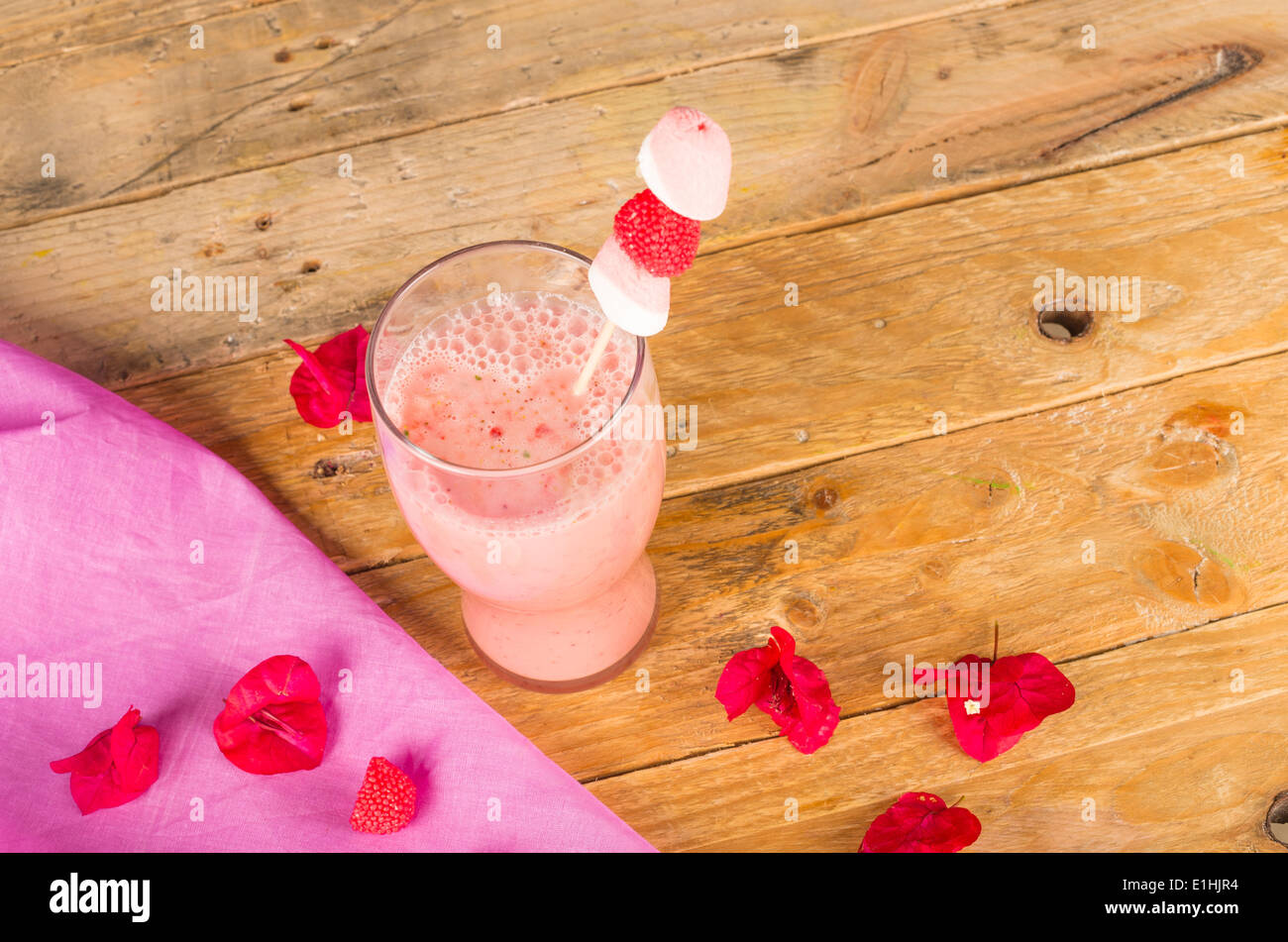 Glass with pink milkshake decorated with candy Stock Photo - Alamy