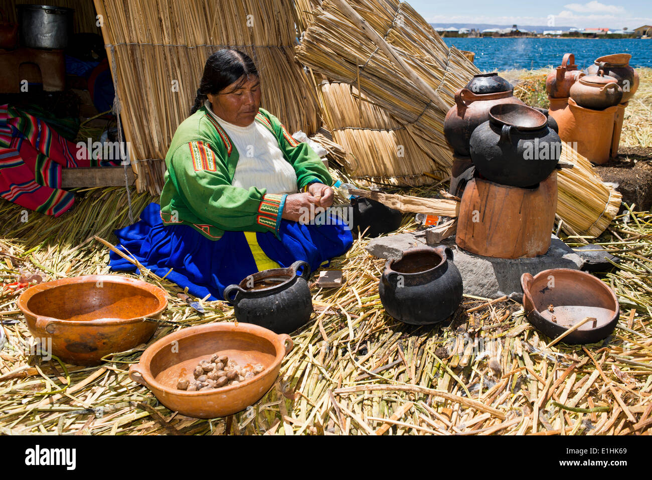 An elderly woman of the Uro Indians wearing typical attire, sitting in ...