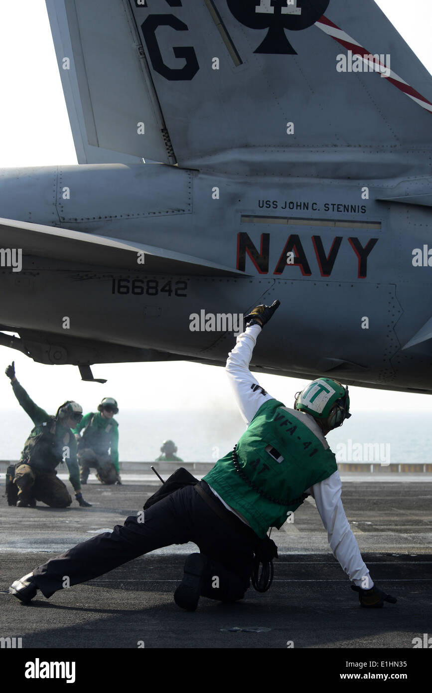 U.S. Sailors signal for the launch of an F/A-18F Super Hornet aircraft ...