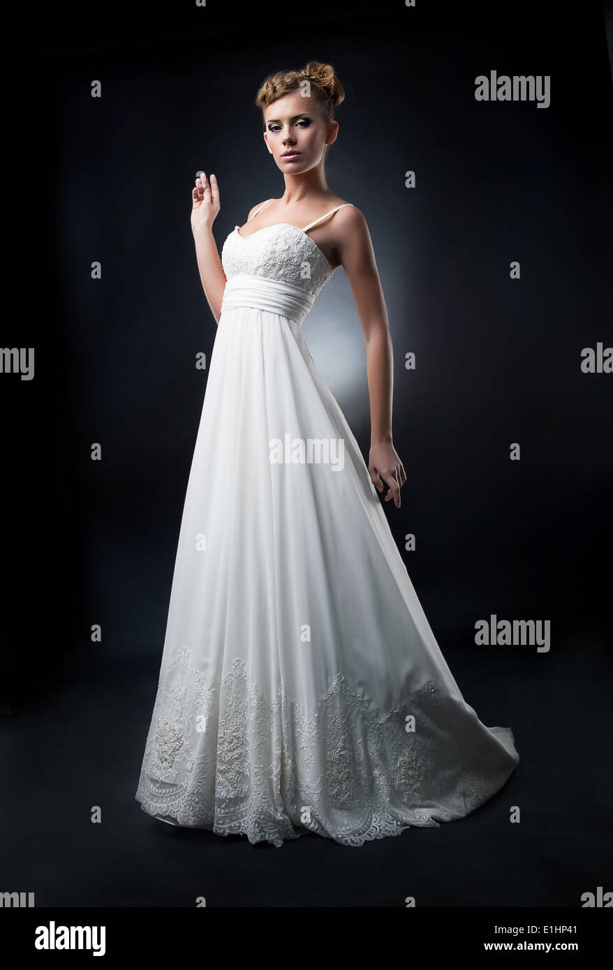Romantic lovely bride fashion model demonstrates white bridal dress on ...