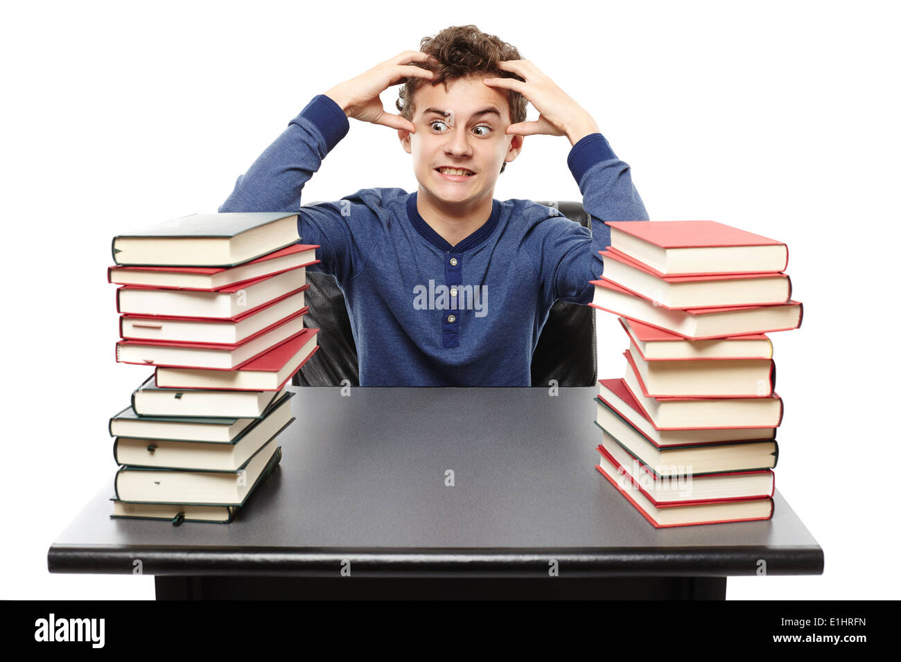Studio shot of hopeless student with face in hands sitting at his desk ...