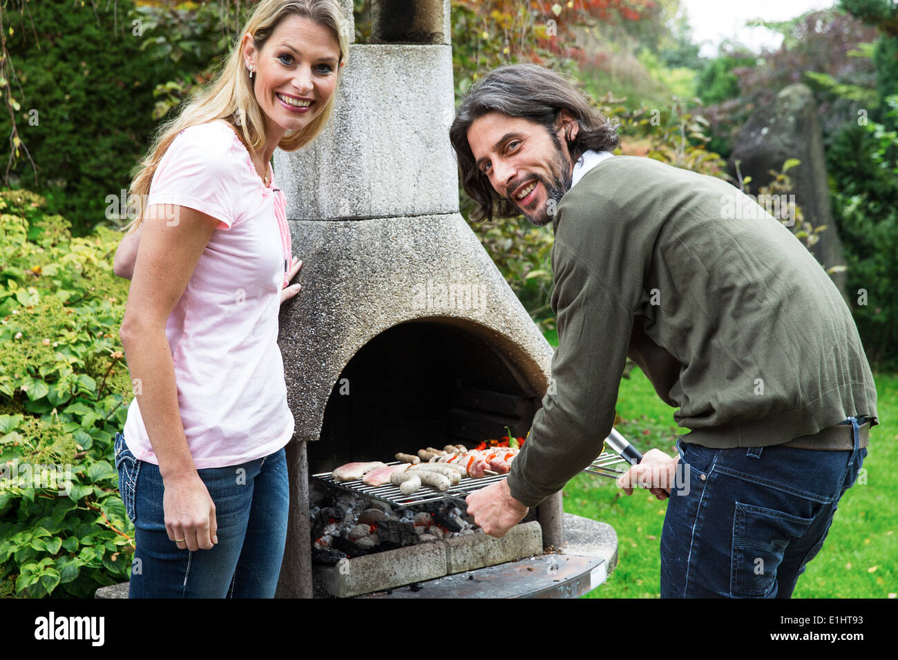 Couple having a barbecue Stock Photo - Alamy