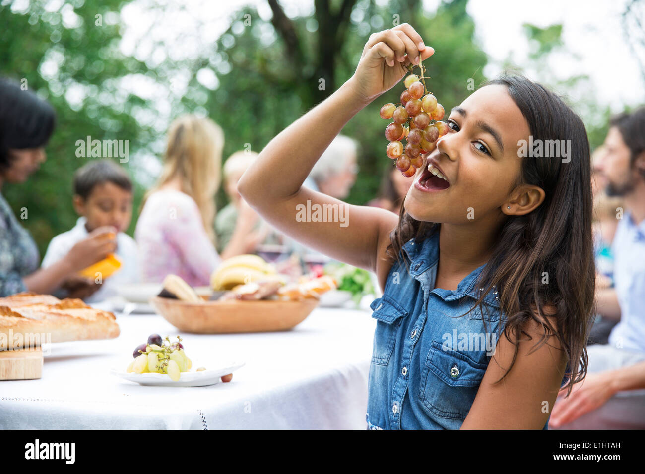 Girl eating grapes on a garden party Stock Photo - Alamy