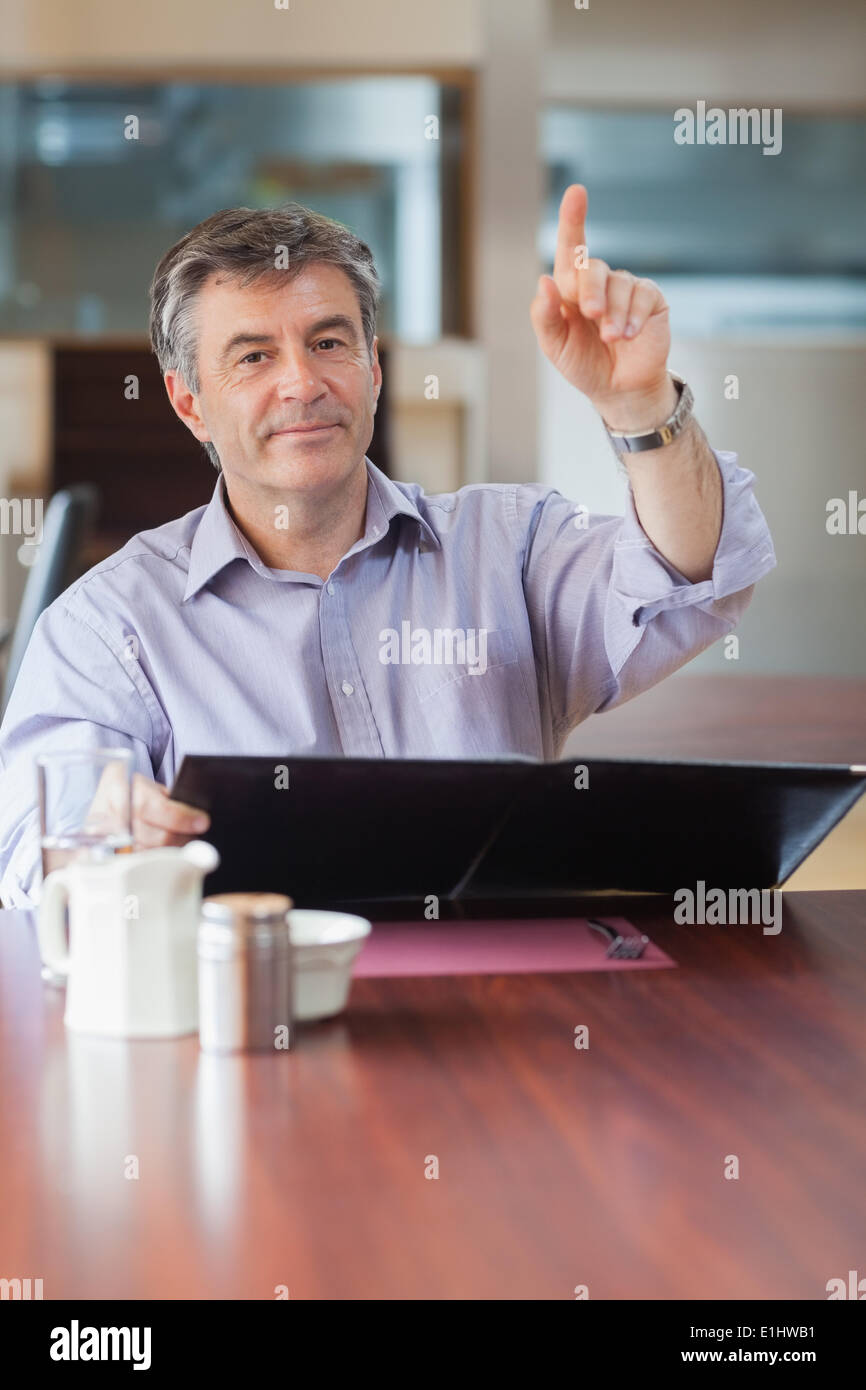 Man in a coffee shop calling a waiter Stock Photo - Alamy