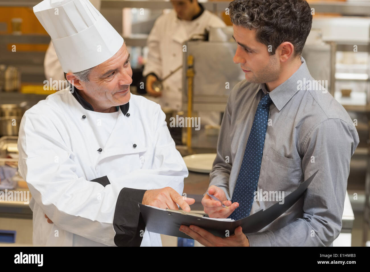 Waiter and chef discussing the menu Stock Photo - Alamy
