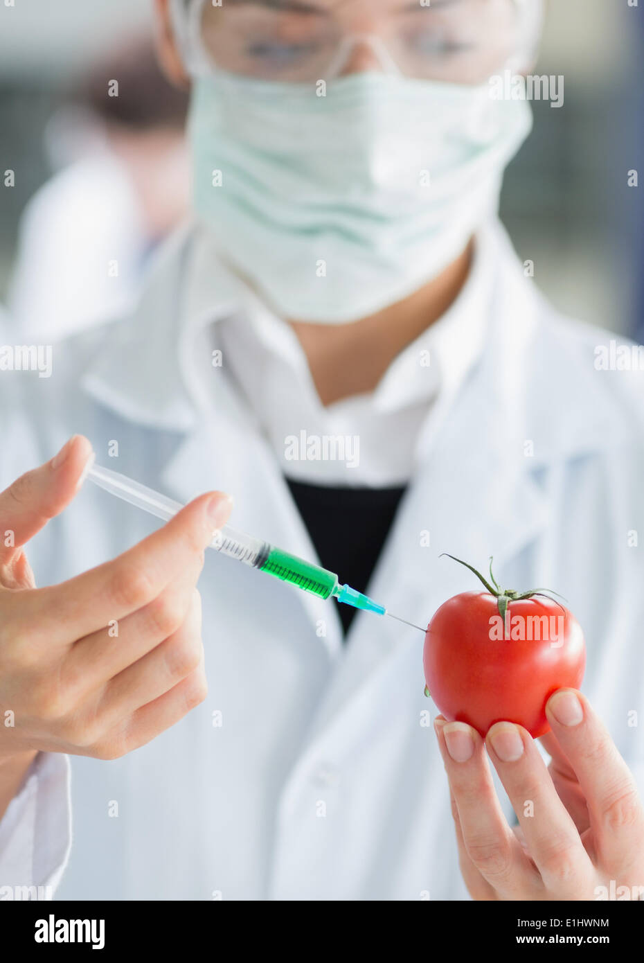 Woman injecting a tomato Stock Photo - Alamy