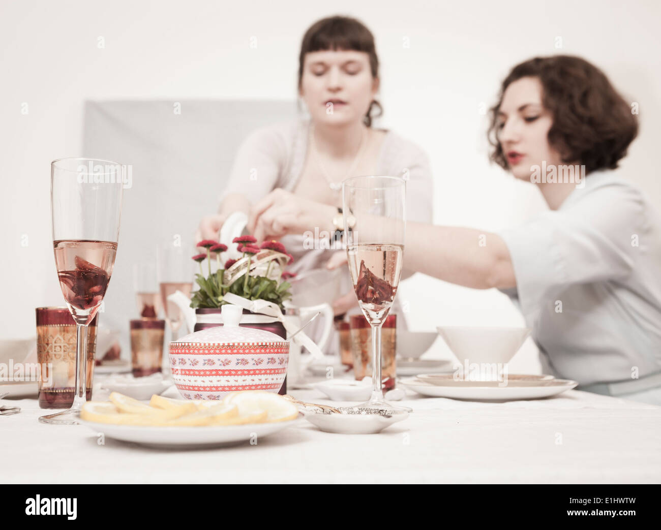 Two young women on a retro style tea party Stock Photo - Alamy