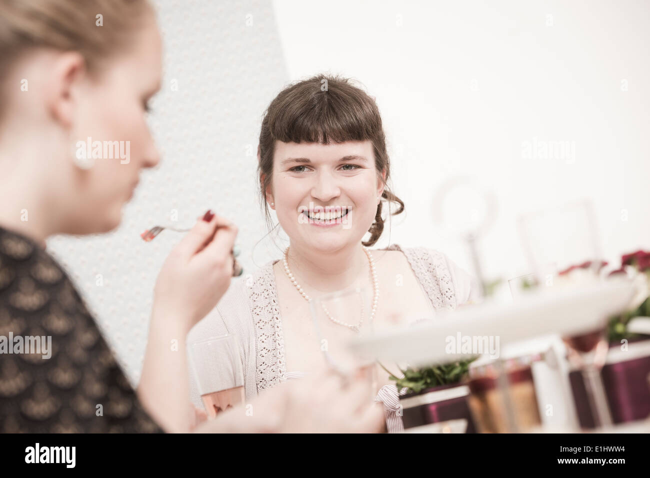 Two young women on a retro style tea party Stock Photo - Alamy