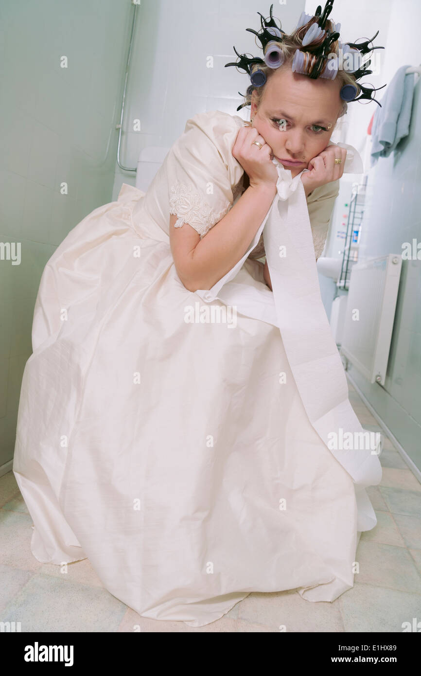 Frustrated bride with curlers sitting on toilet Stock Photo - Alamy