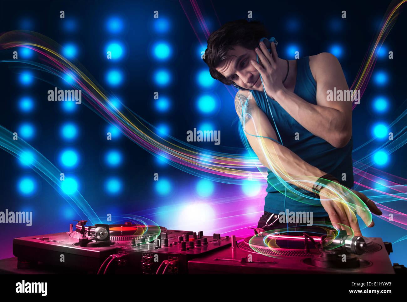 Young Dj mixing records with colorful lights Stock Photo - Alamy
