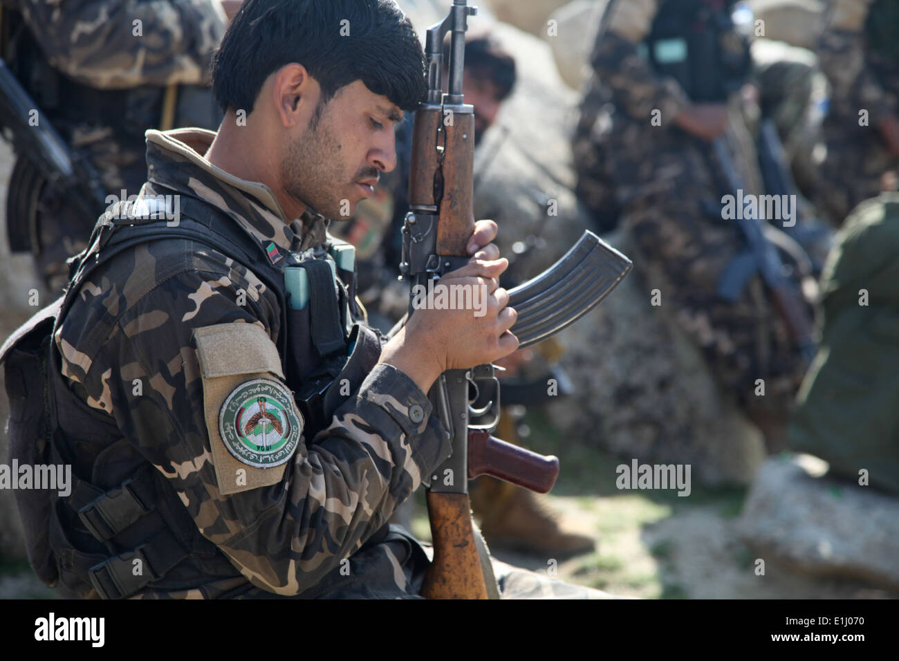 An Afghan National Directorate of Security member examines his weapon ...