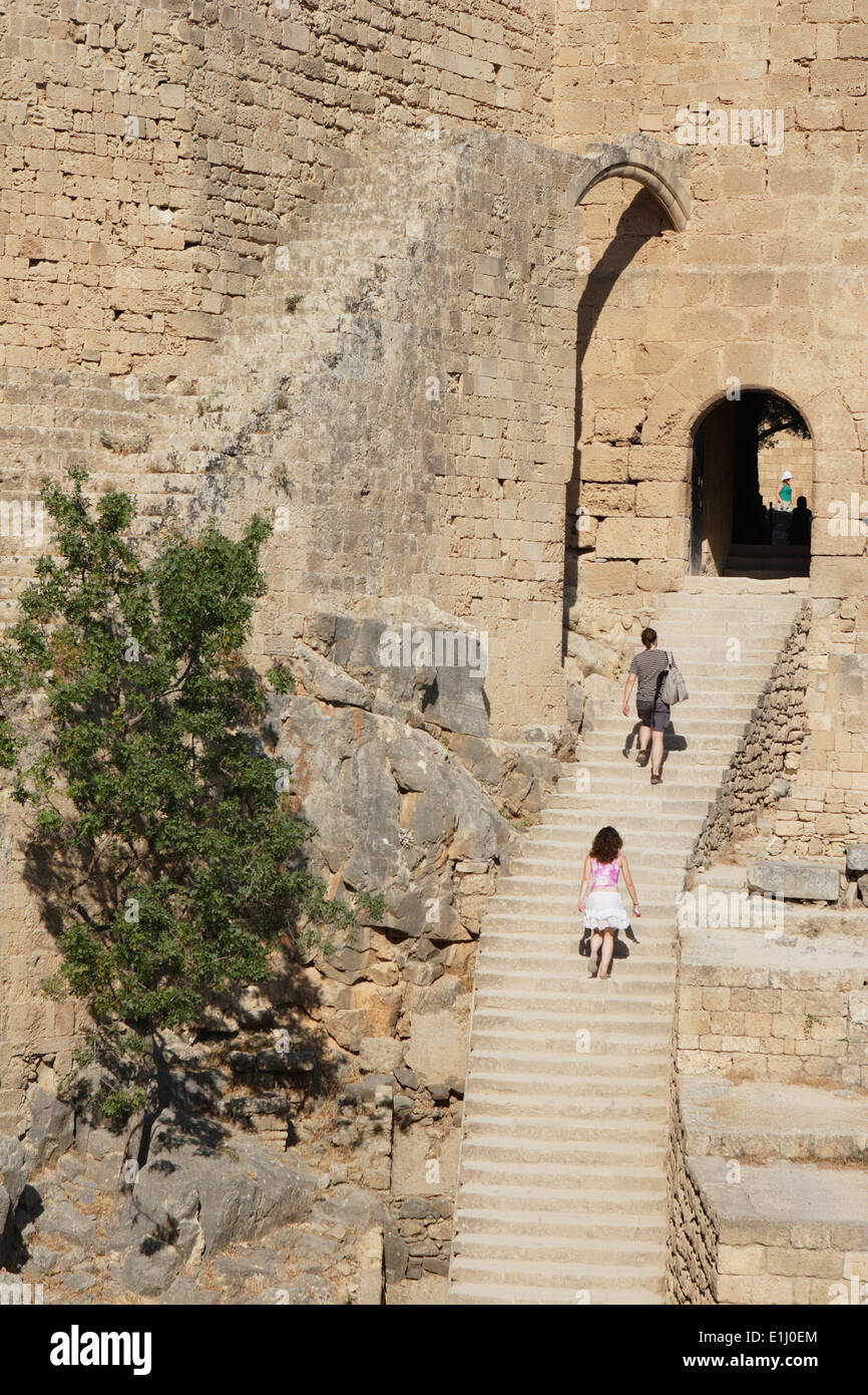 Woman in a white dress walking up steps to views the ruins of the ...