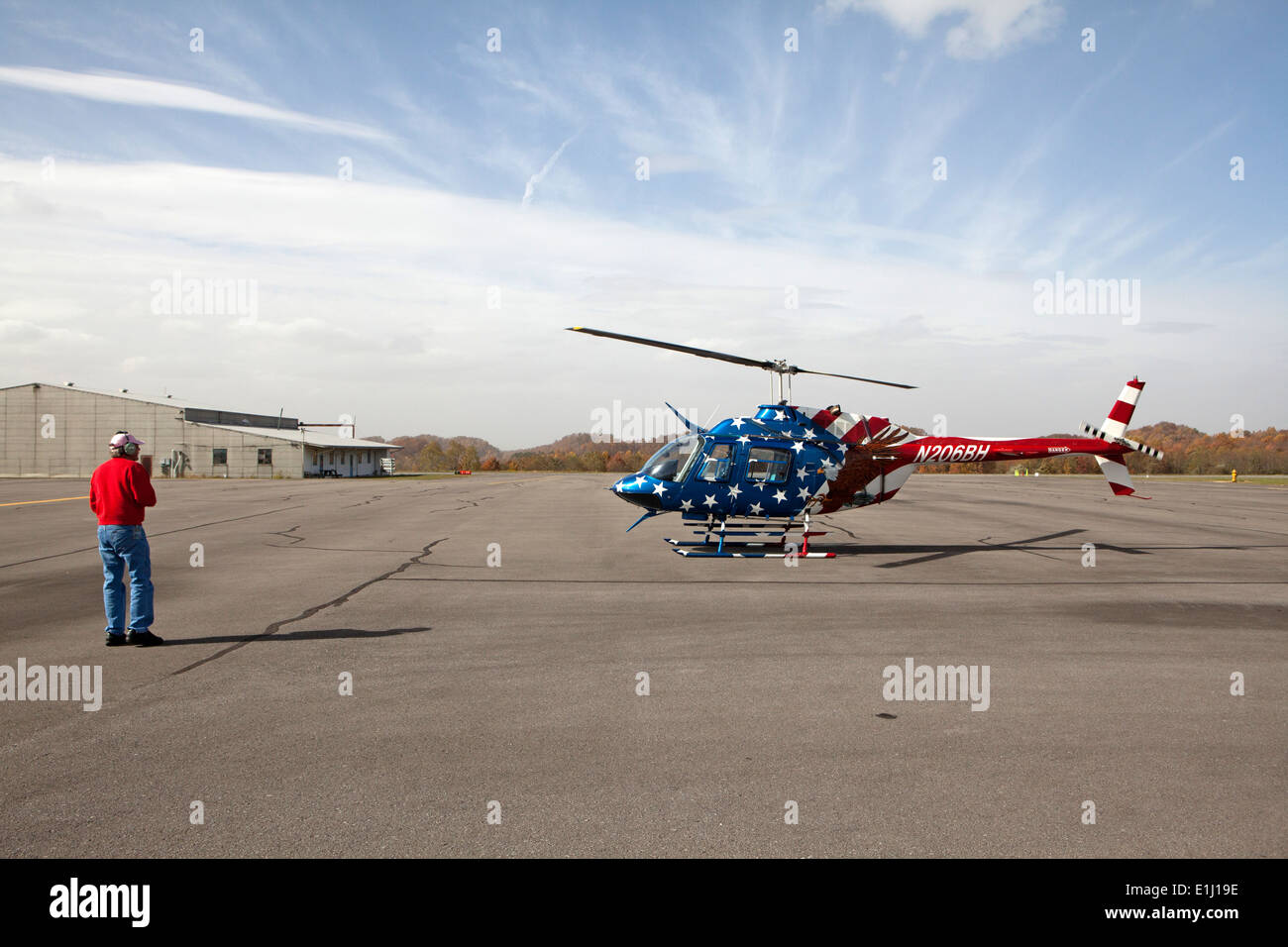 Patriotic helicopter pilot on airport tarmac with helicopter decorated ...