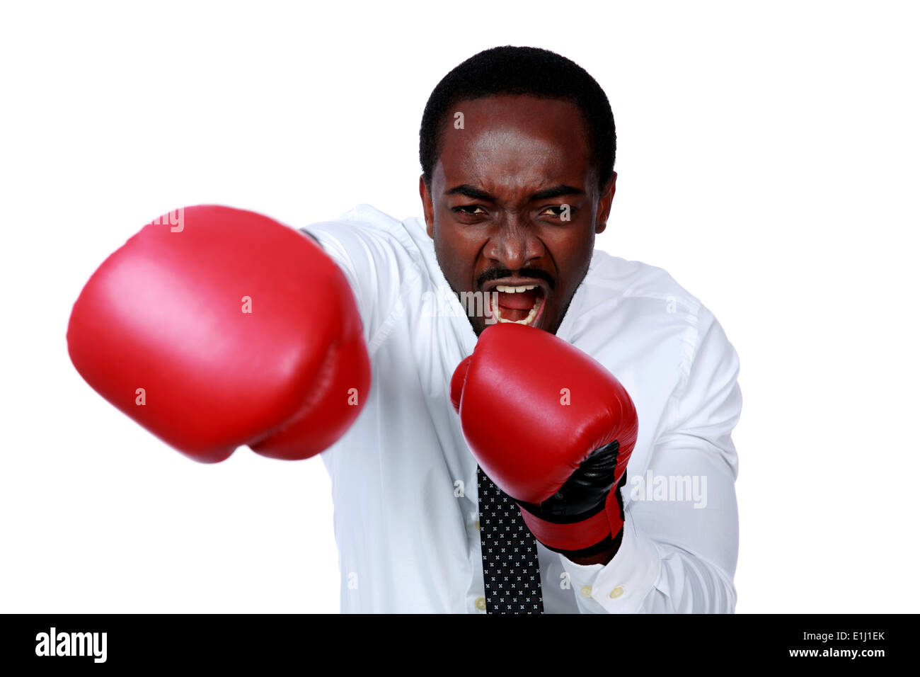 Angry businessman ready to punch you over gray background Stock Photo ...