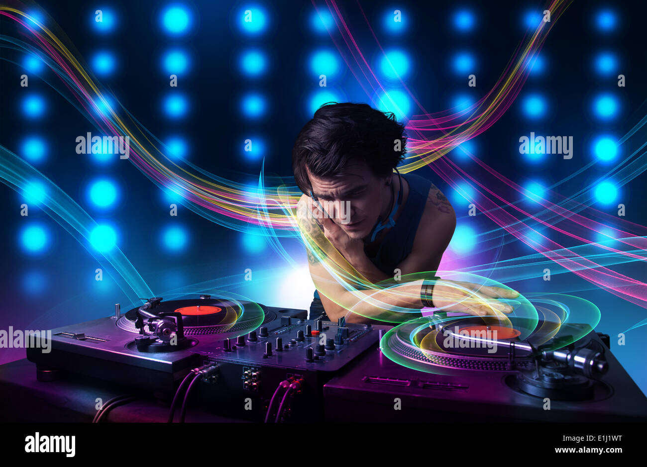 Young Dj mixing records with colorful lights Stock Photo - Alamy