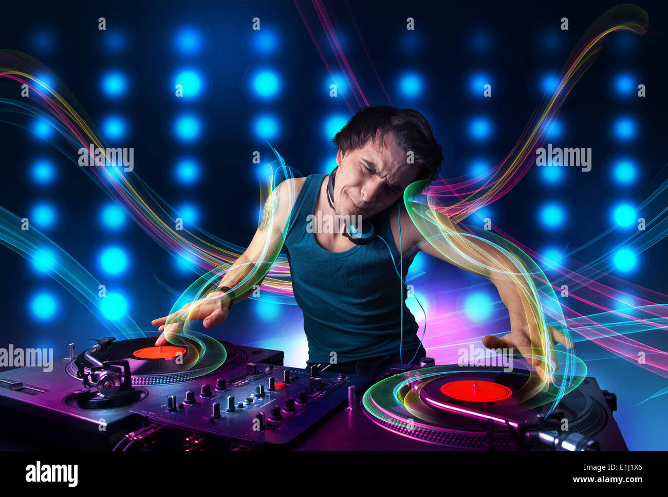 Young Dj mixing records with colorful lights Stock Photo - Alamy