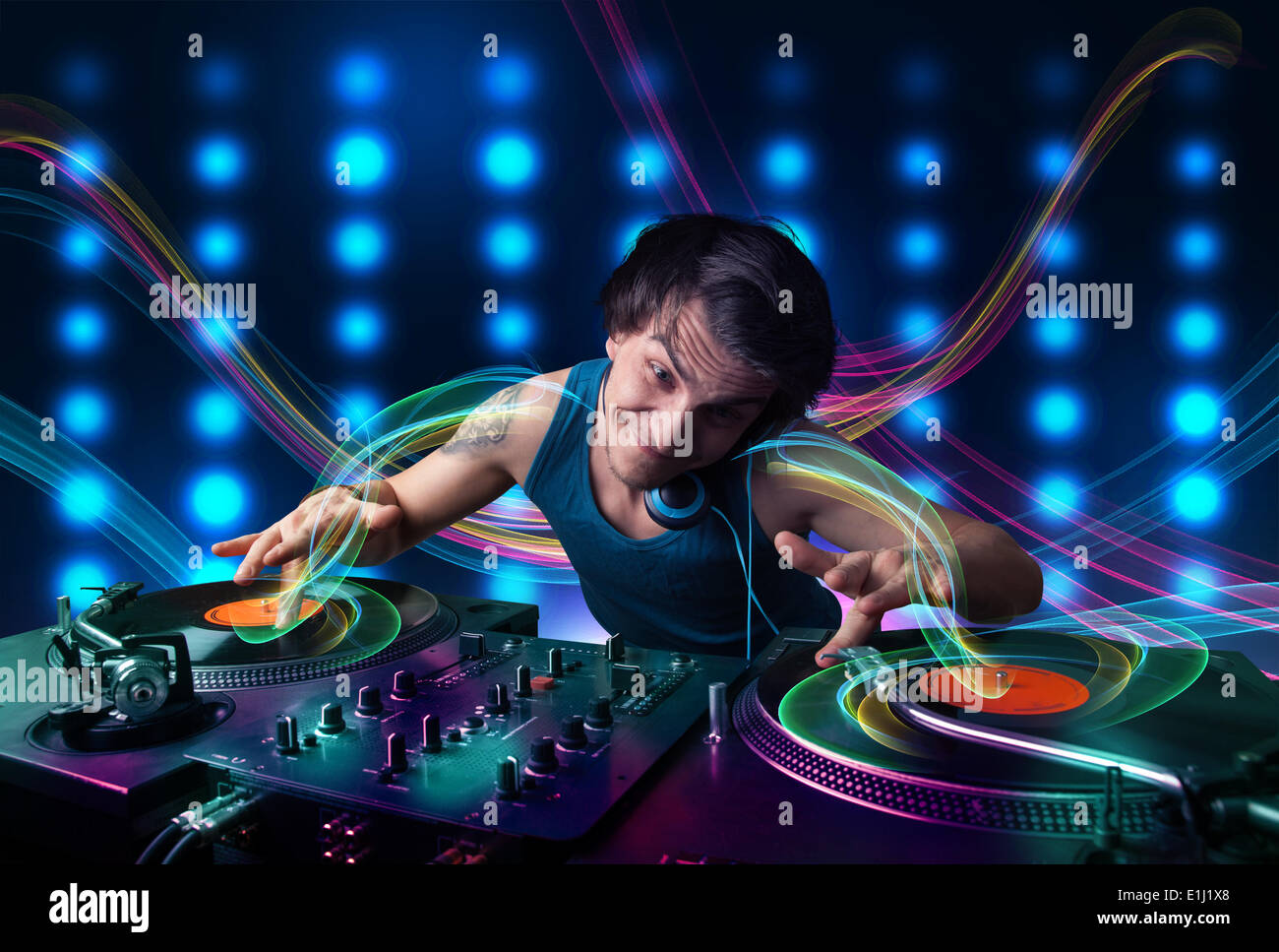Young Dj mixing records with colorful lights Stock Photo - Alamy