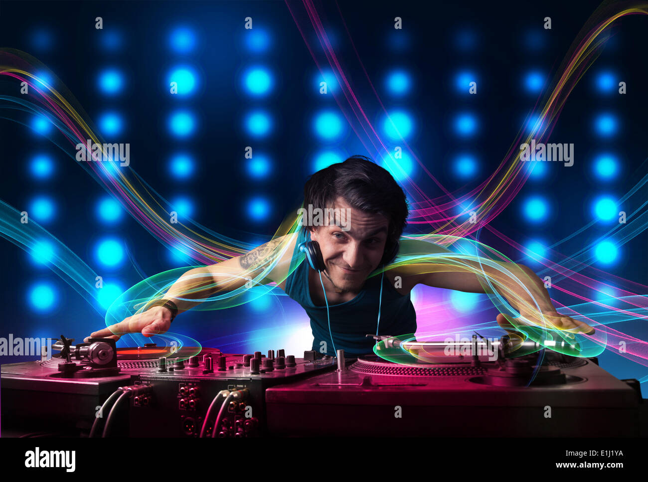 Young Dj mixing records with colorful lights Stock Photo - Alamy