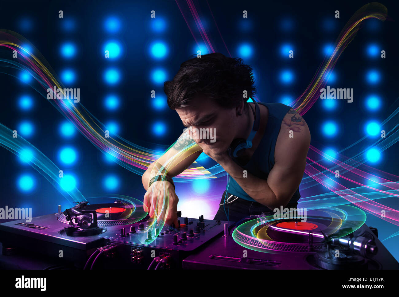 Young Dj mixing records with colorful lights Stock Photo - Alamy