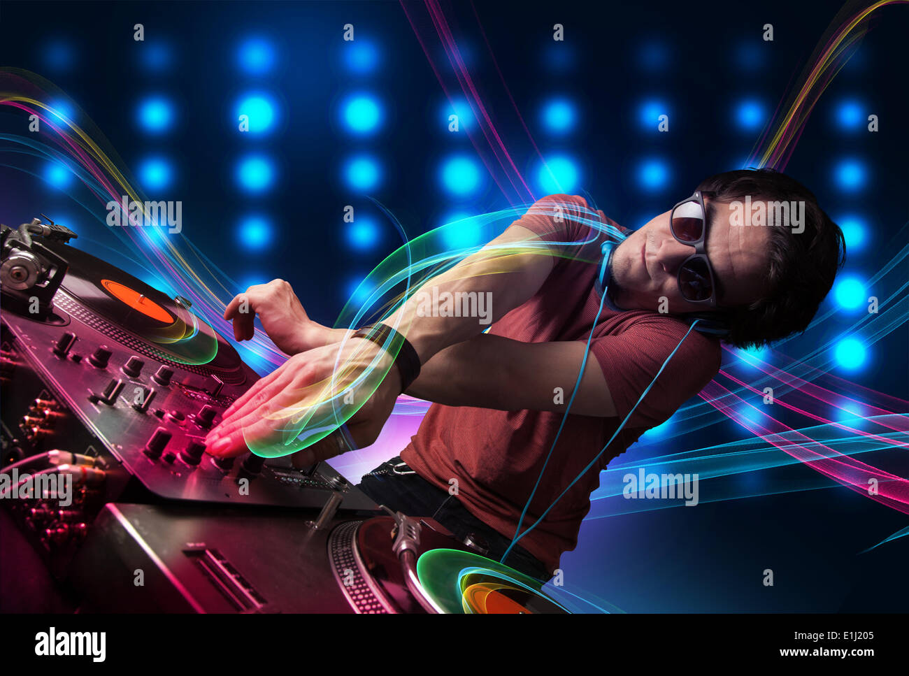 Young Dj mixing records with colorful lights Stock Photo - Alamy