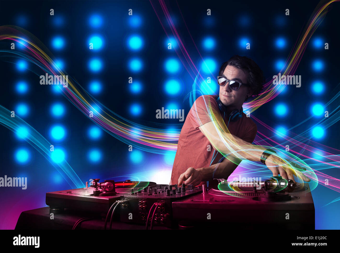 Young Dj mixing records with colorful lights Stock Photo - Alamy