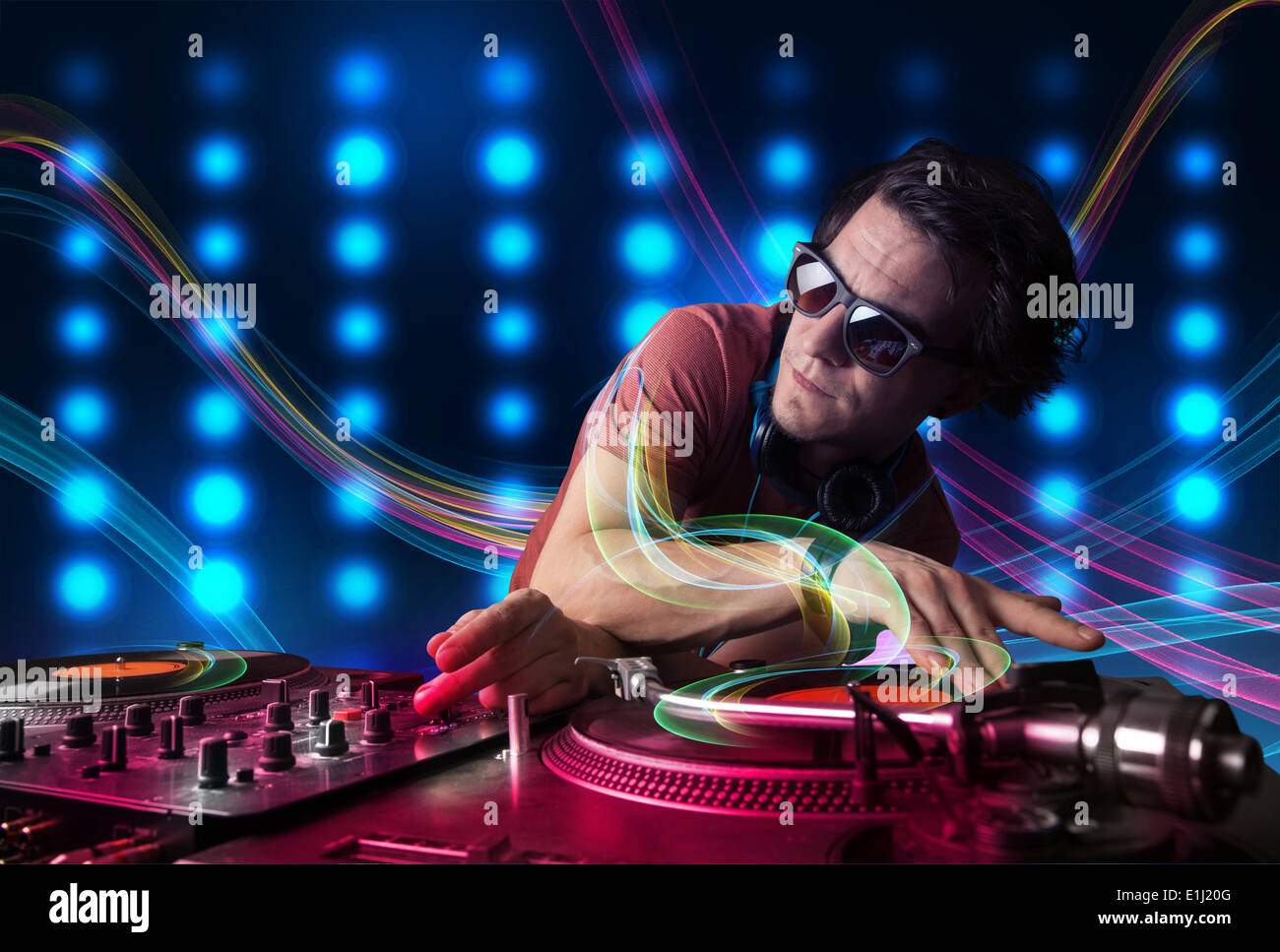 Young Dj mixing records with colorful lights Stock Photo - Alamy