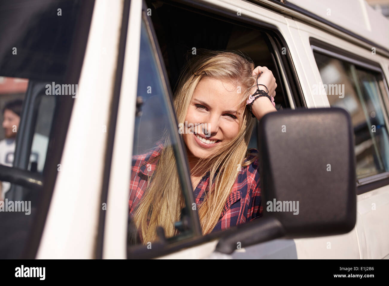 Smiling young woman in minivan Stock Photo - Alamy