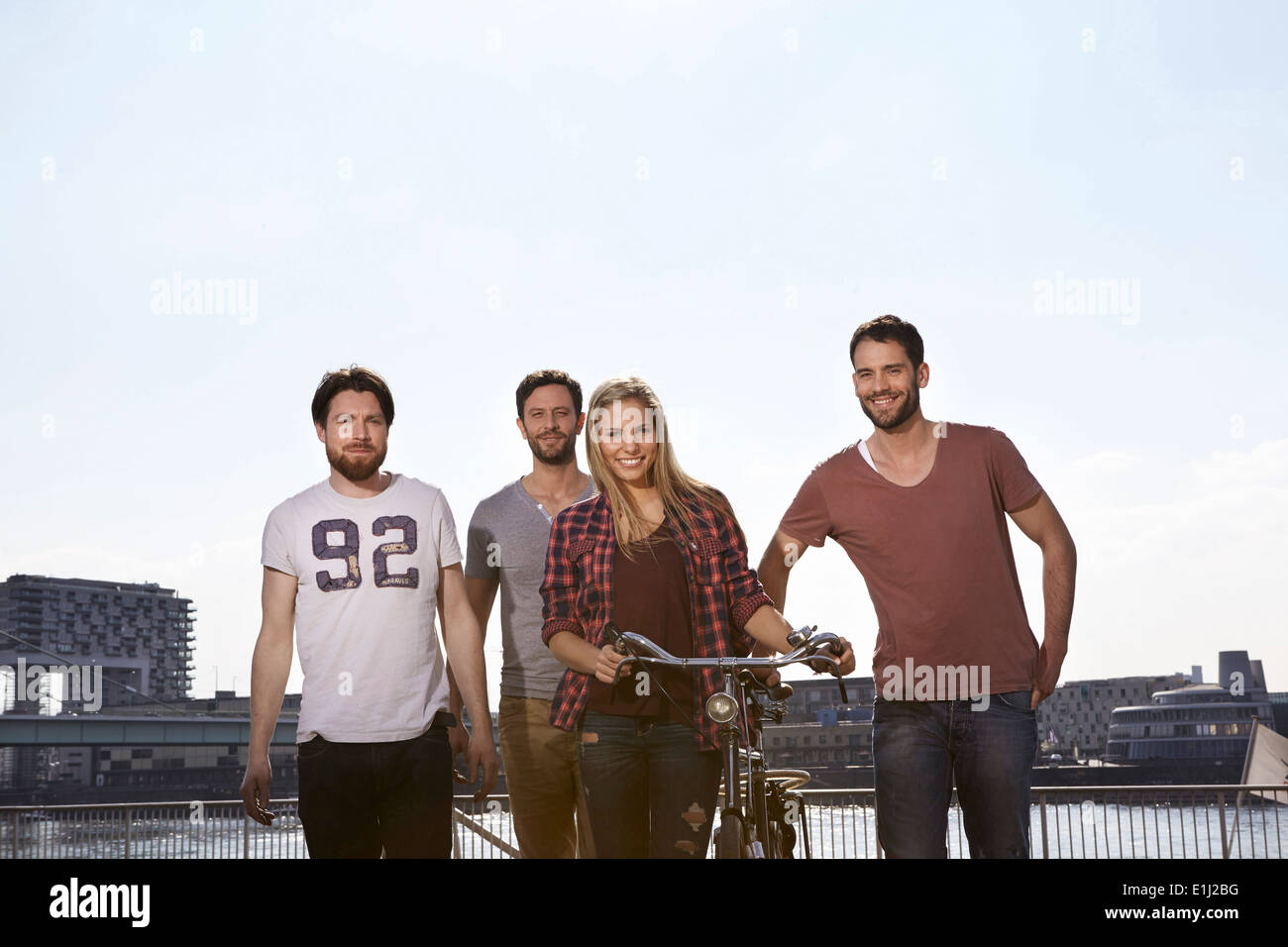 Four smiling friends with bicycle Stock Photo - Alamy