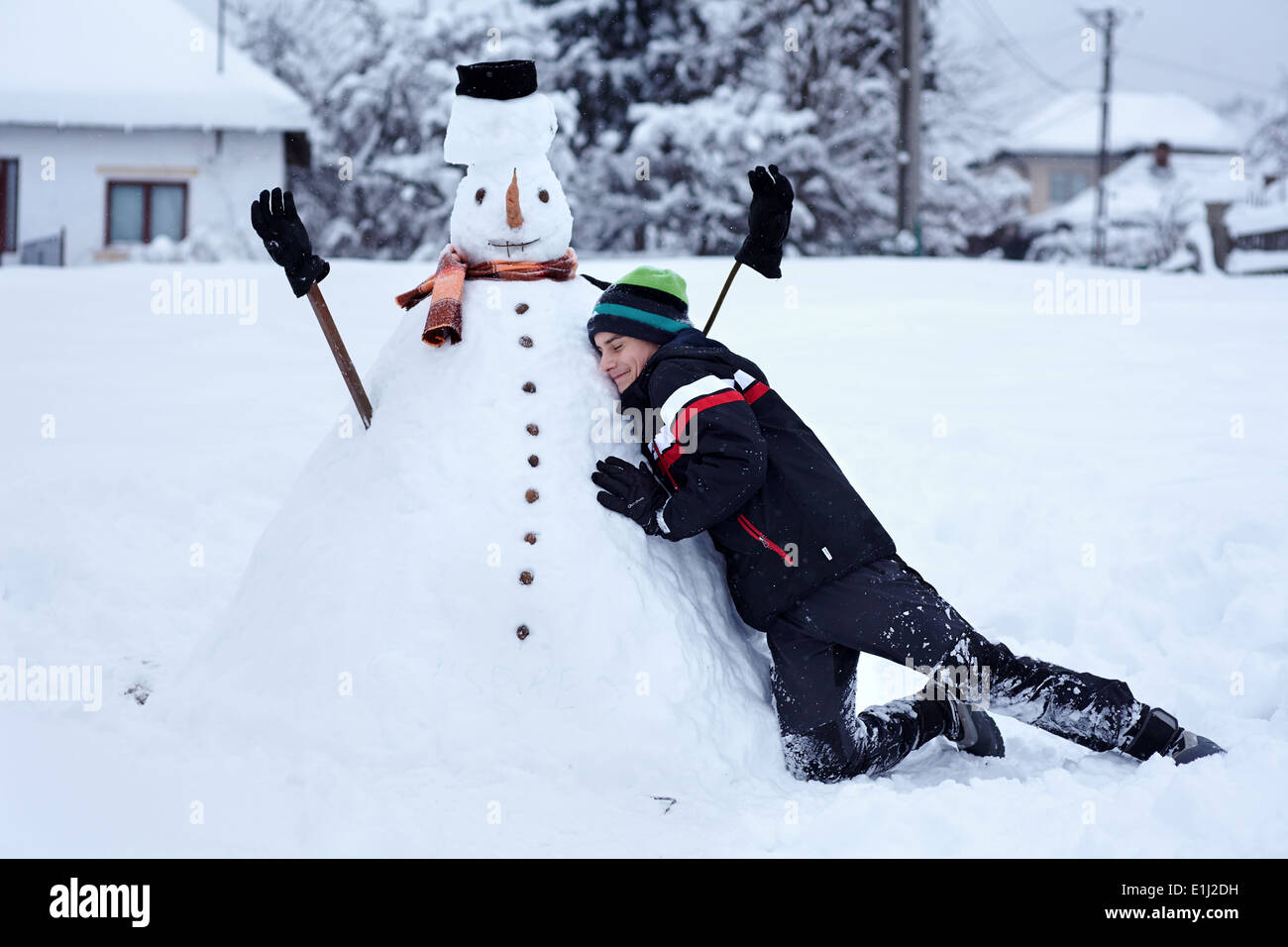 Teenage boy building a snowman in the countryside Stock Photo - Alamy