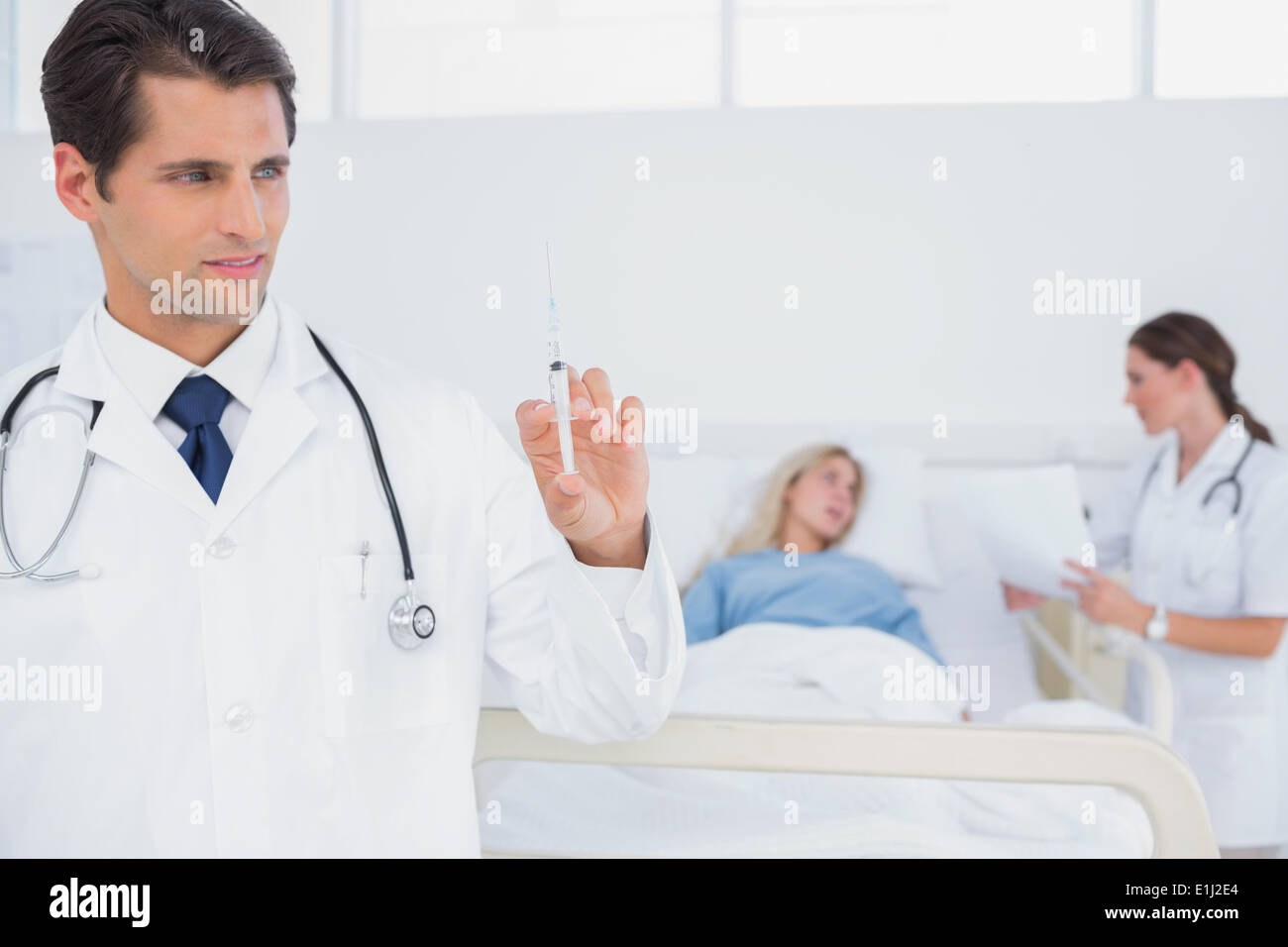 Handsome male doctor holding injection hi-res stock photography and ...