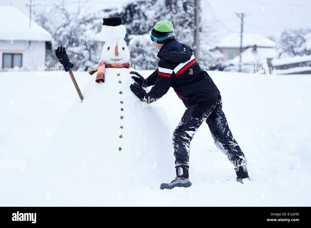 Teenage boy building a snowman in the countryside Stock Photo - Alamy