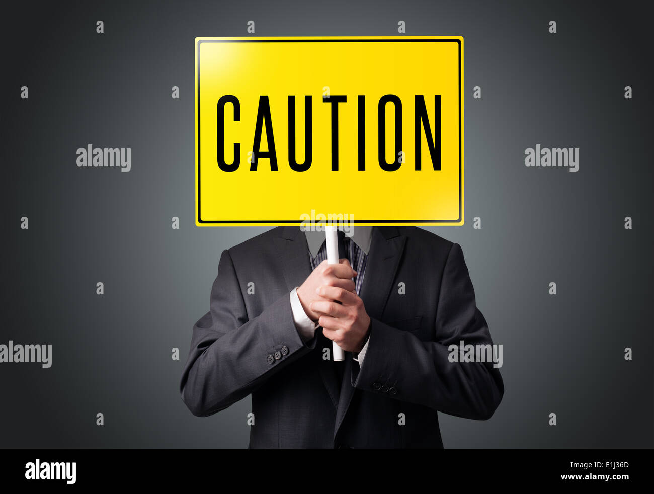 Businessman holding a caution sign Stock Photo - Alamy
