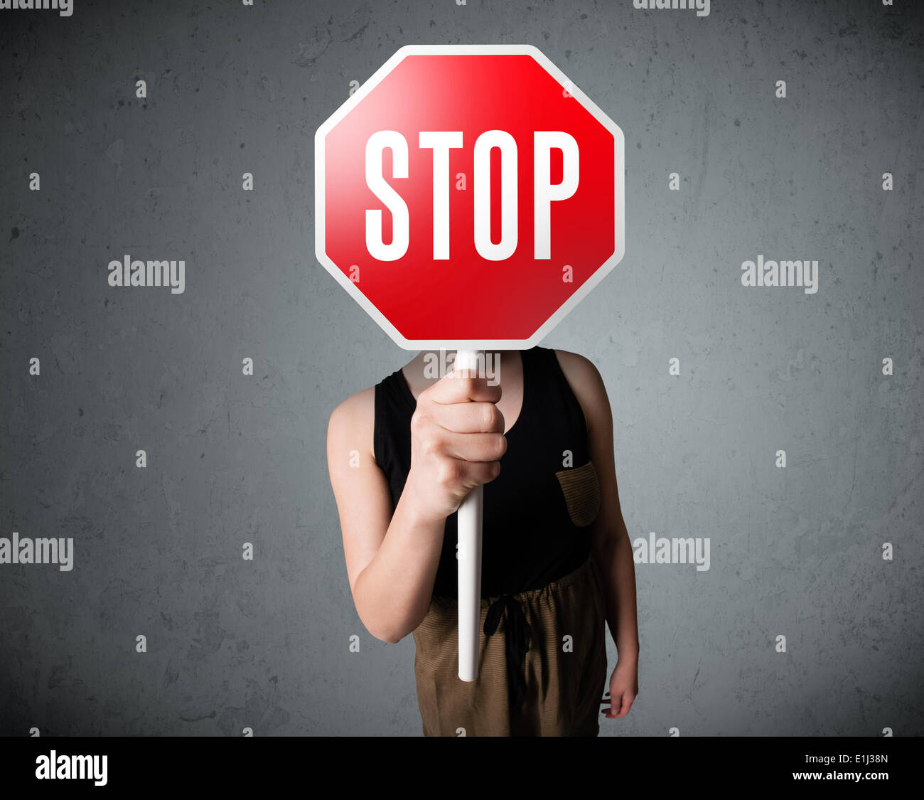 Young woman holding a stop sign Stock Photo - Alamy