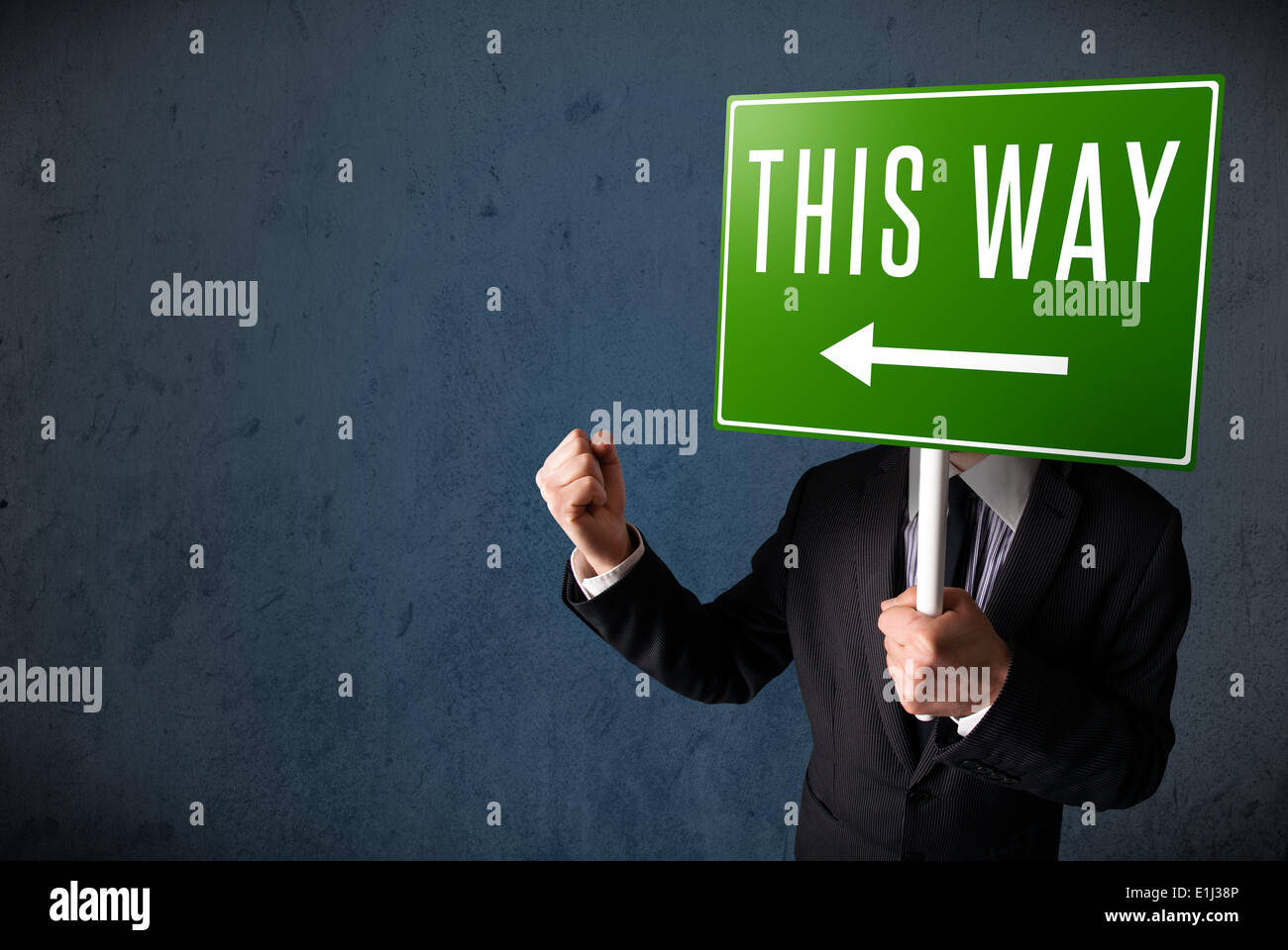 Businessman holding a direction sign Stock Photo - Alamy