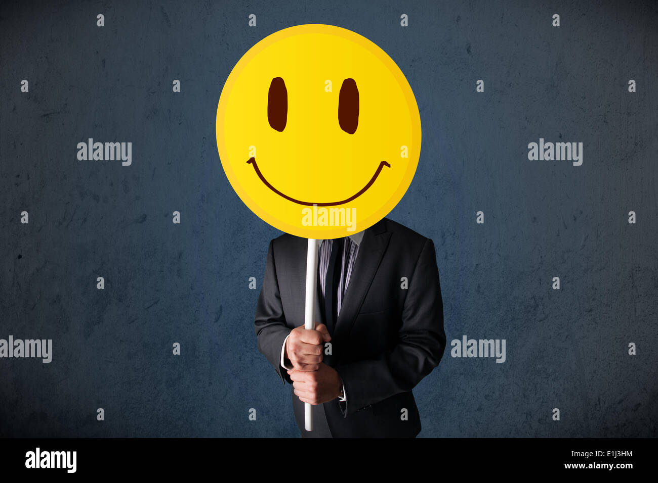 Businessman holding a smiley face emoticon Stock Photo - Alamy