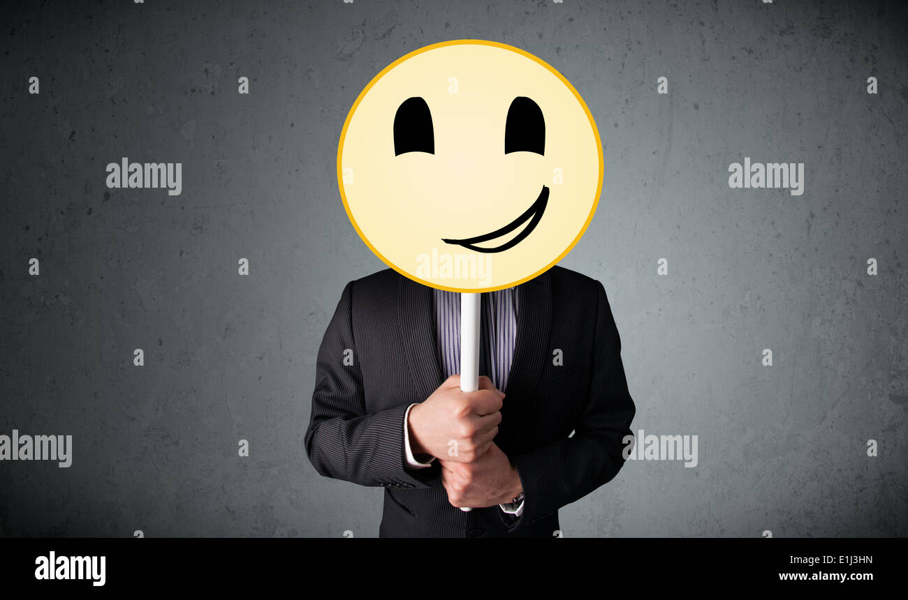 Businessman holding a smiley face emoticon Stock Photo - Alamy