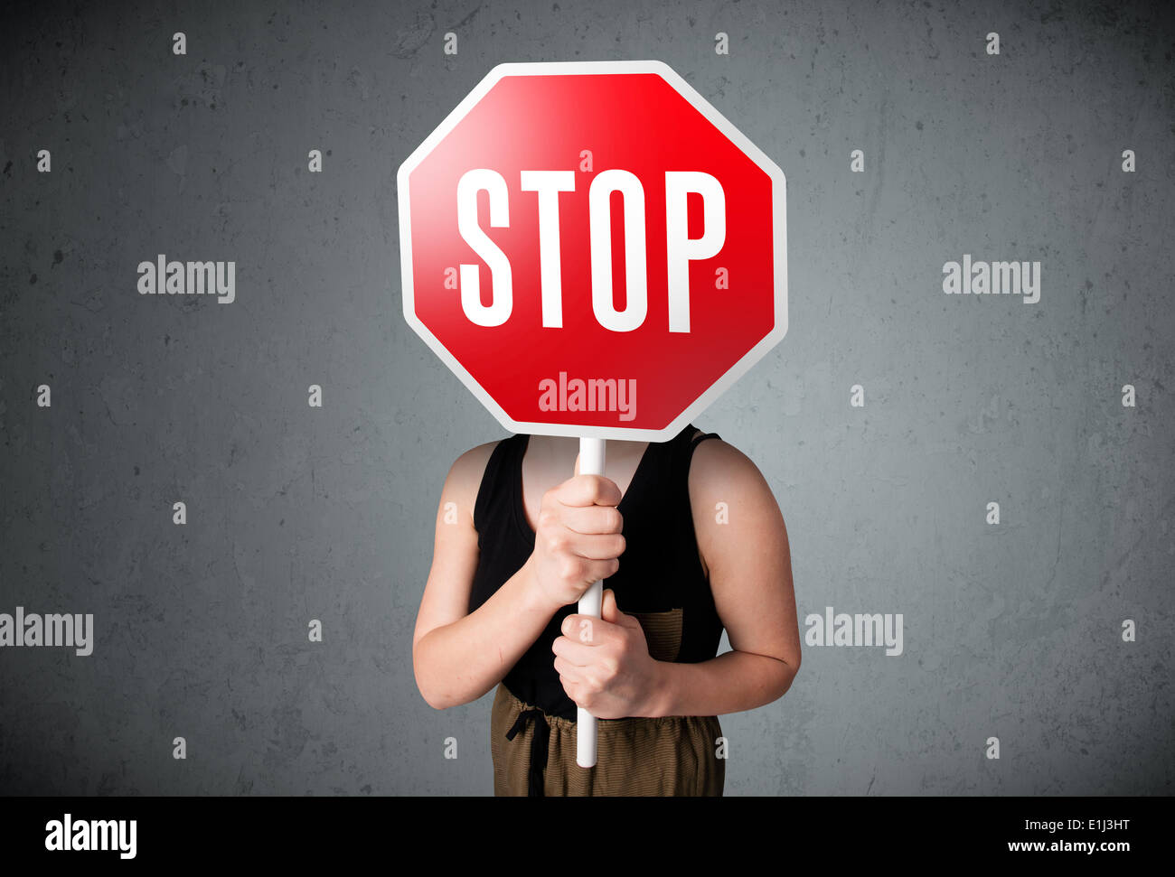 Young woman holding a stop sign Stock Photo - Alamy