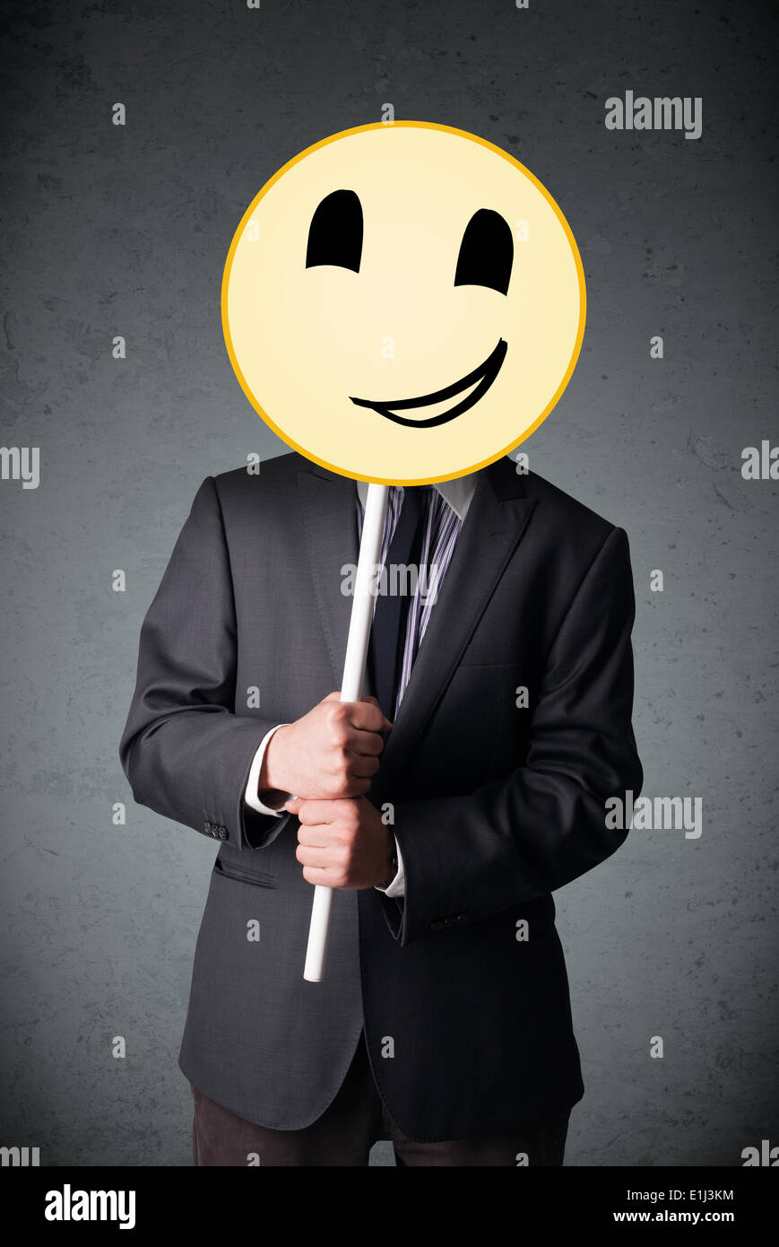 Businessman holding a smiley face emoticon Stock Photo - Alamy