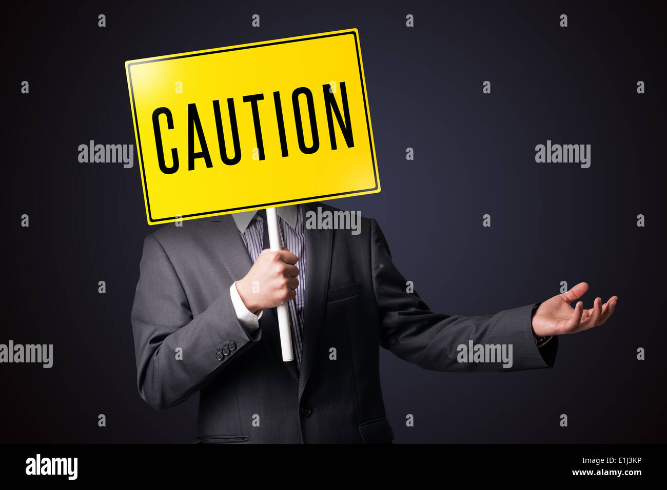 Businessman holding a caution sign Stock Photo - Alamy