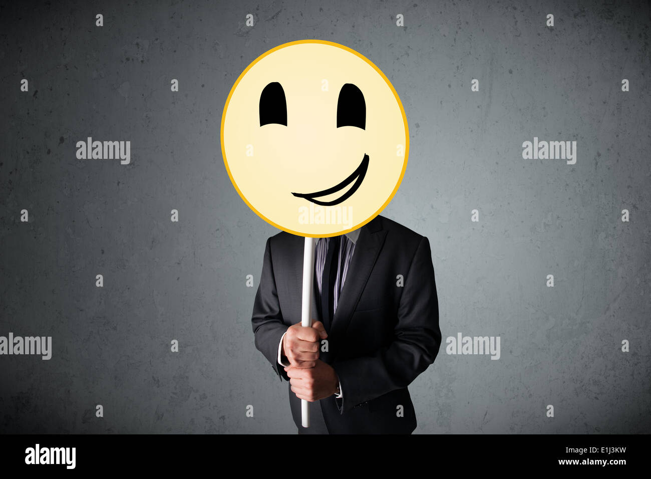 Businessman holding a smiley face emoticon Stock Photo - Alamy